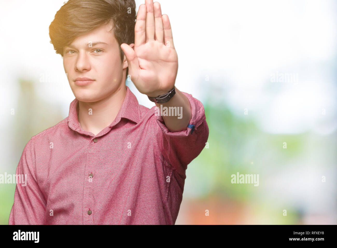 Beau jeune homme d'affaires au fond isolé faisant arrêter de chanter ...