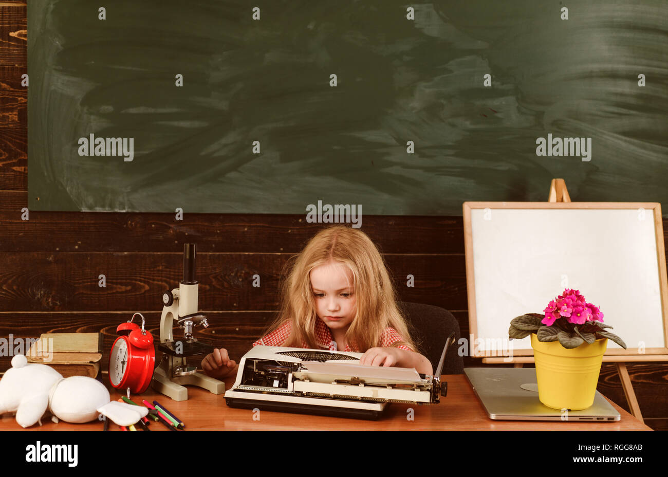 Petite fille de dactylographier sur vintage machine à écrire à l'école ...