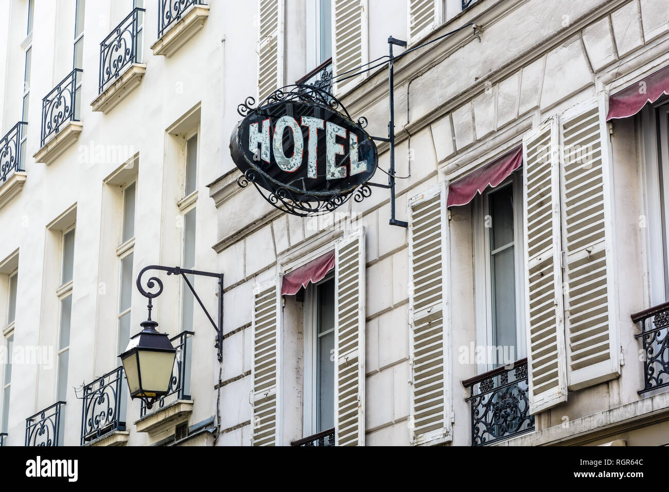 L'usure du panneau en fer forgé d'un modeste hôtel sur la façade d'un ...