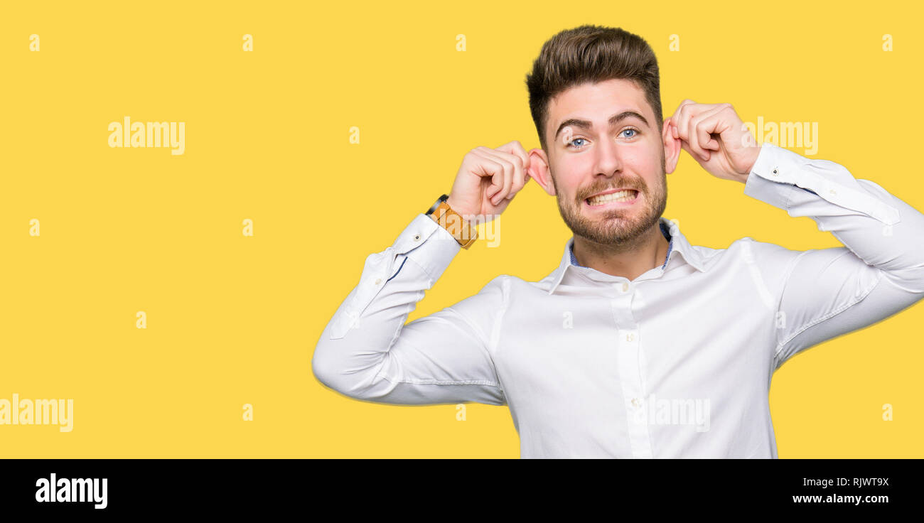 Young handsome man Smiling tirant les oreilles avec les doigts, geste ...