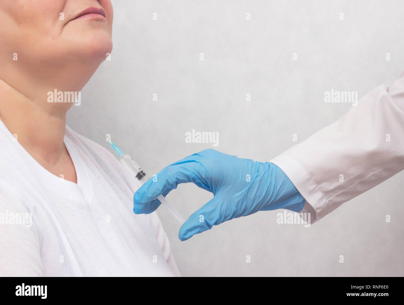 Le docteur fait la femme de percer la glande thyroïde pour clarifier le ...