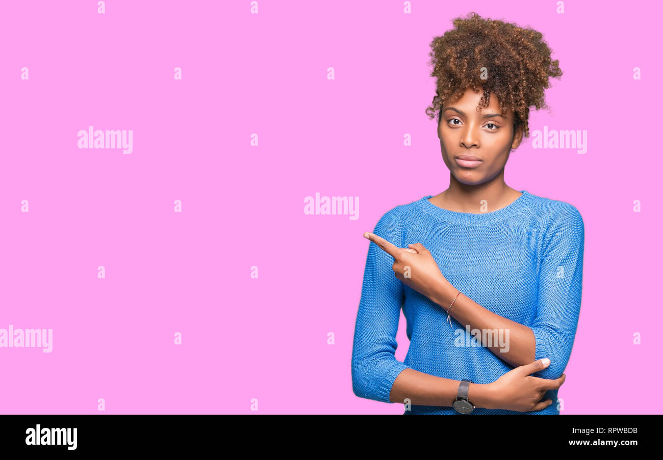 Belle jeune femme afro-américaine sur fond isolé pointant du doigt à la ...