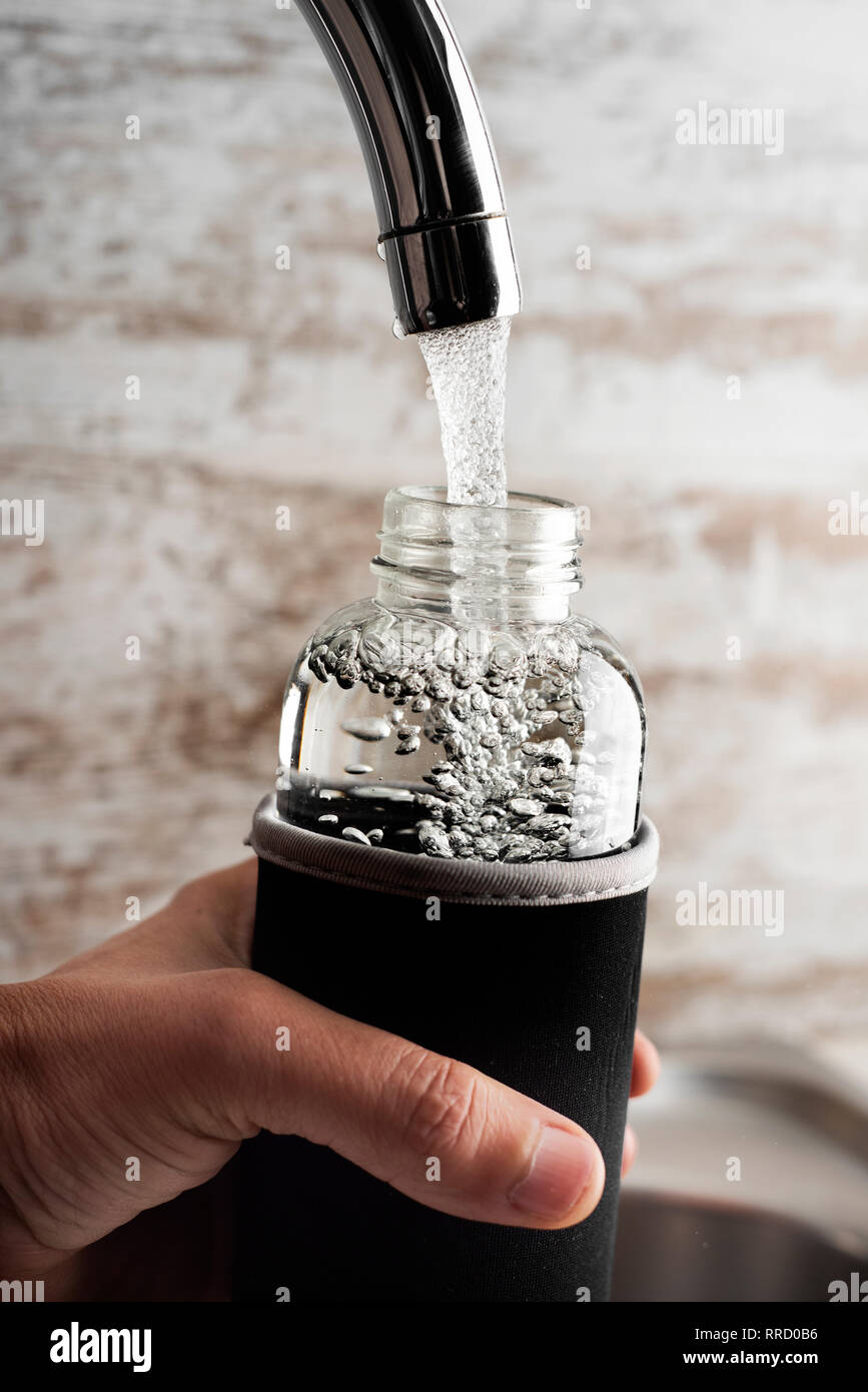 Libre d'un jeune homme cacausian remplir une bouteille d'eau ... Libre d'un jeune homme cacausian remplir une bouteille d'eau ...