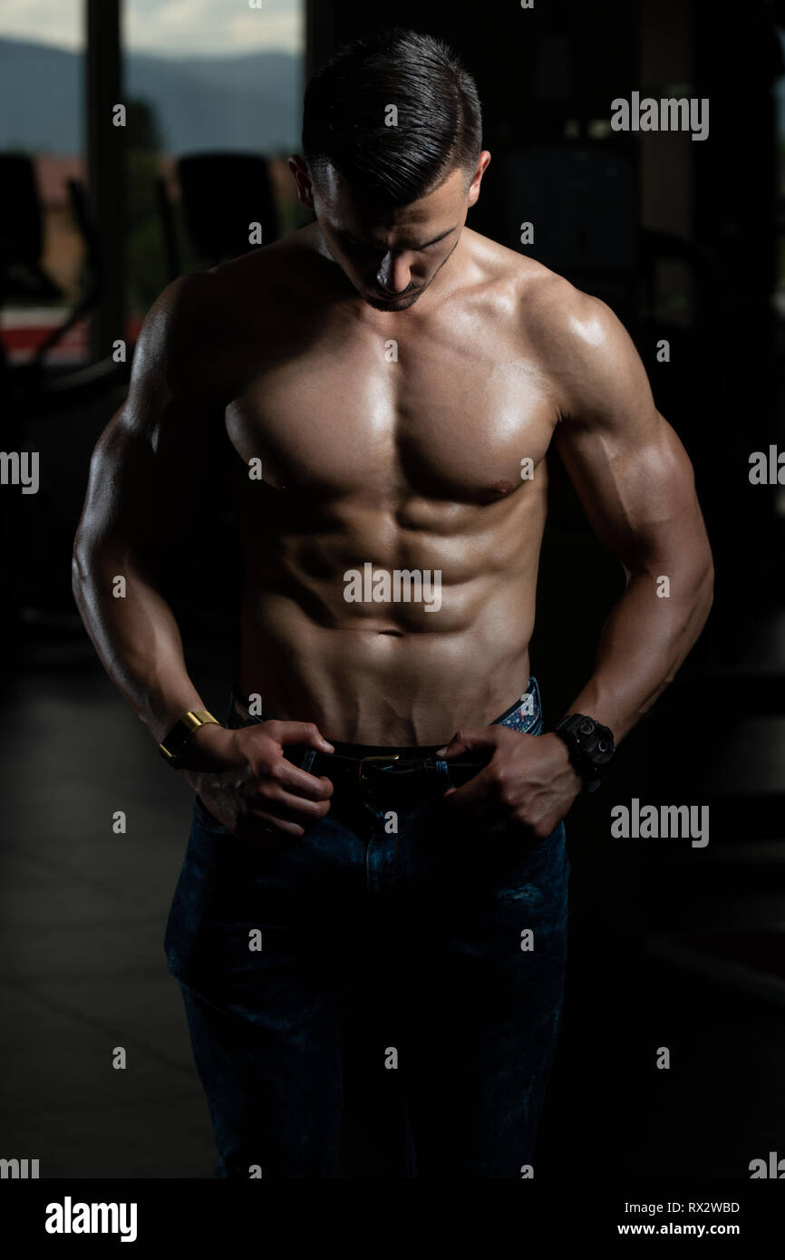 Portrait d'un jeune homme en bonne forme physique en jeans montrant son ...