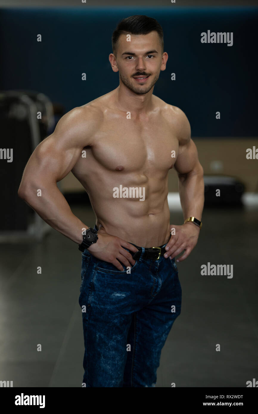 Portrait d'un jeune homme en bonne forme physique en jeans montrant son ...