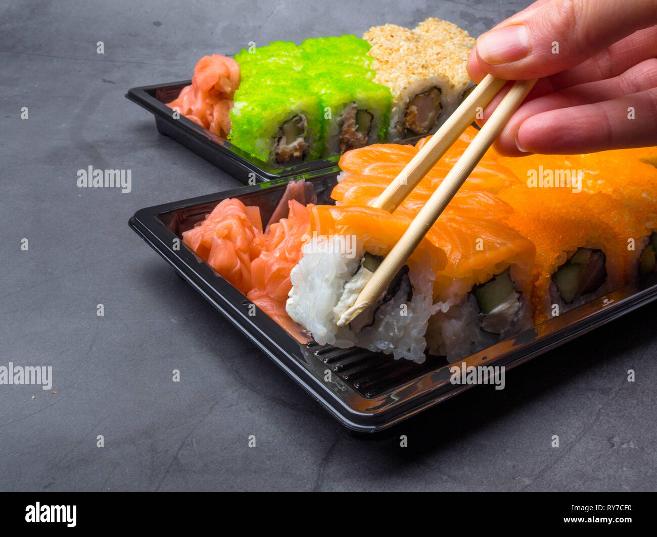 Délicieux sushi bar, manger des sushis avec des baguettes. Sushi roll ...