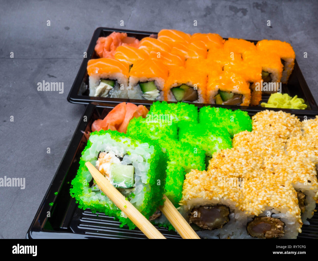 Délicieux sushi bar, manger des sushis avec des baguettes. Sushi roll ...