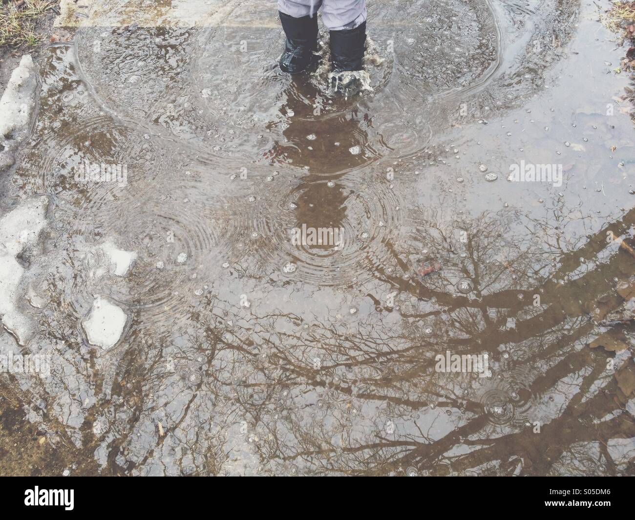 Enfant sautant dans une flaque d'eau Banque de photographies et d ...