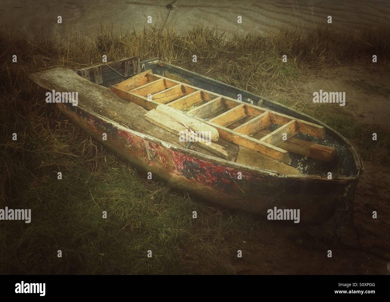 Bateau à rames en bois sur la rive avec une échelle et le bois à l ...