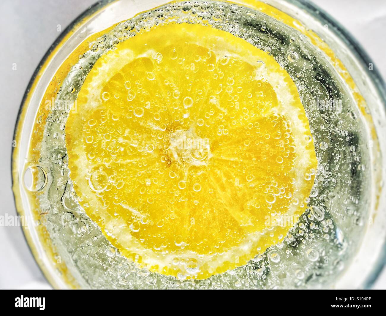 Une tranche de citron flottant dans un verre d'eau minérale gazeuse ...