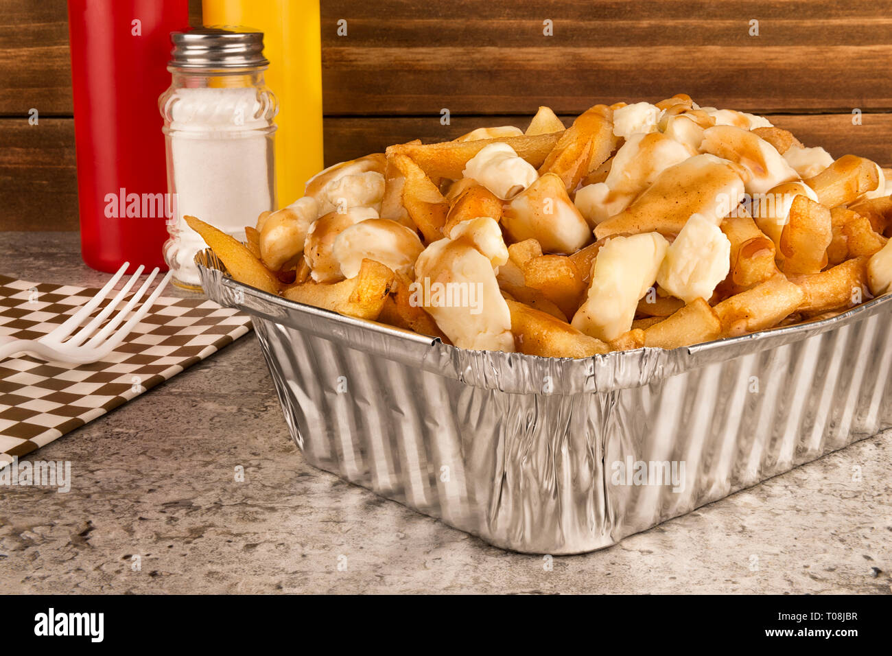 La poutine dans un récipient pour emporter. Cuite avec des frites, du ...