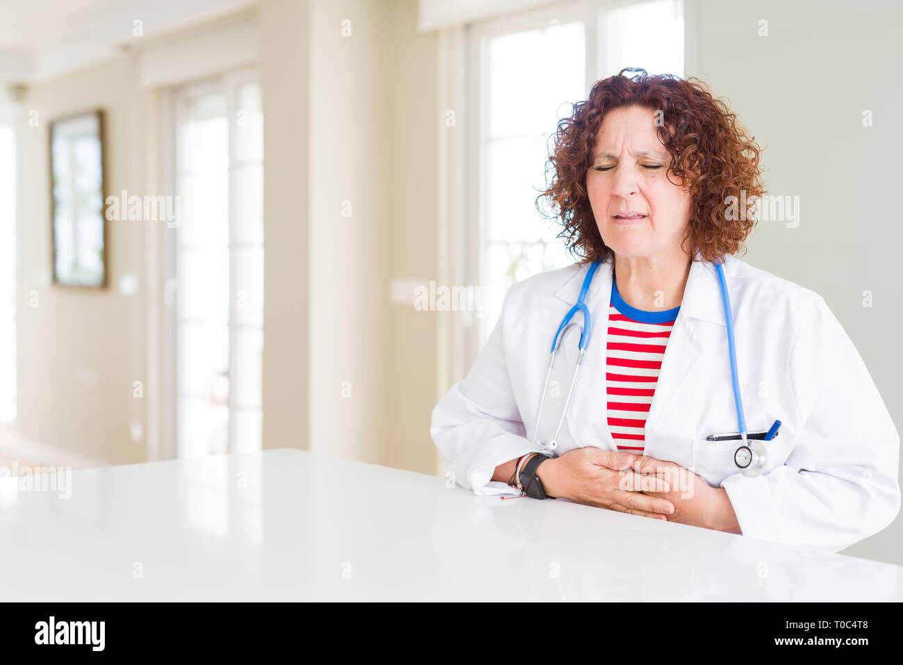 Médecin Senior woman wearing robe médical à la clinique avec la main ...