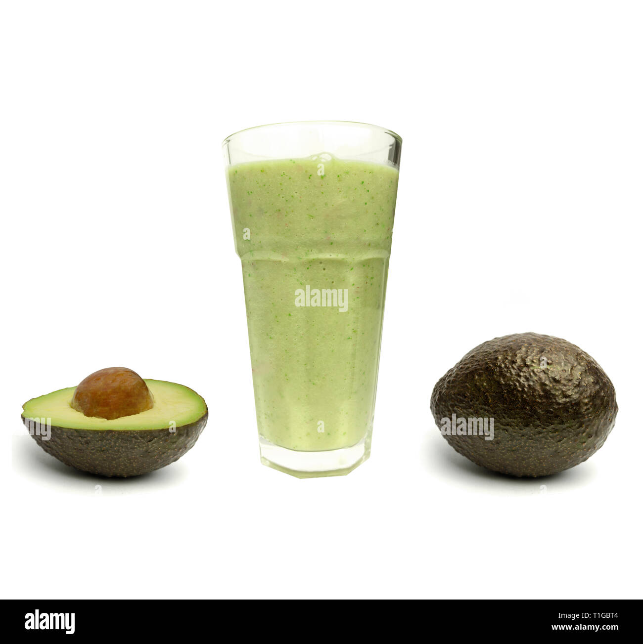 Close-up d'un verre de smoothie à l'avocat avec la moitié de l'avocat ...