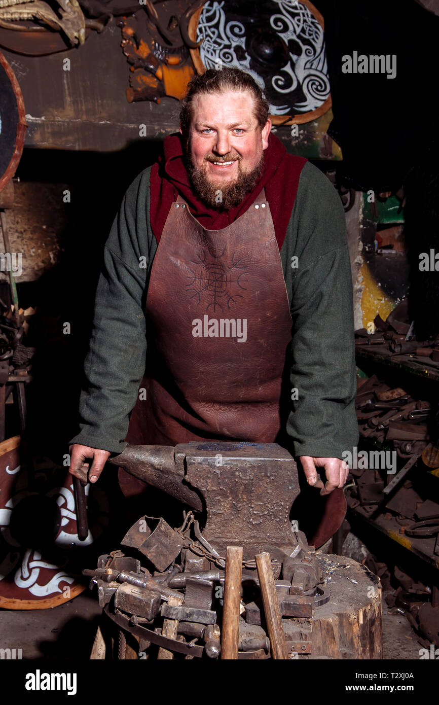 Armes et épées Viking forges dans la forge. Un homme en habits de ...