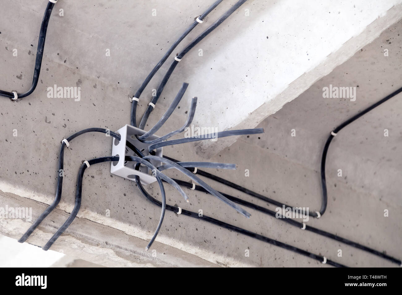 La pose de câbles au plafond. Les fils électriques sur le mur ...