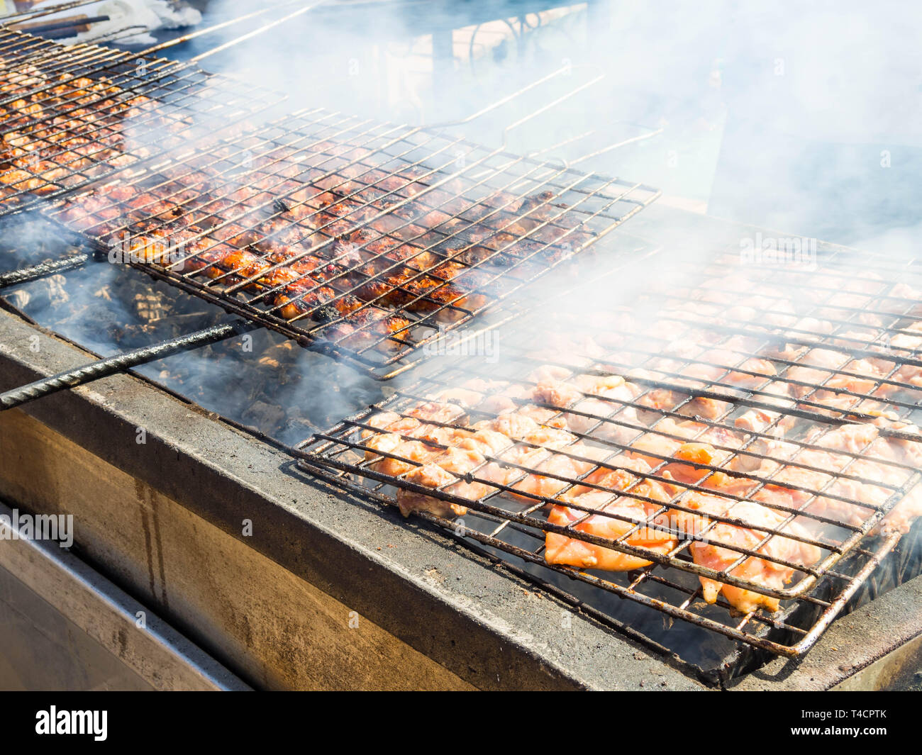 La viande grillée au charbon de barbecue cuisinière avec plein de fumée ...
