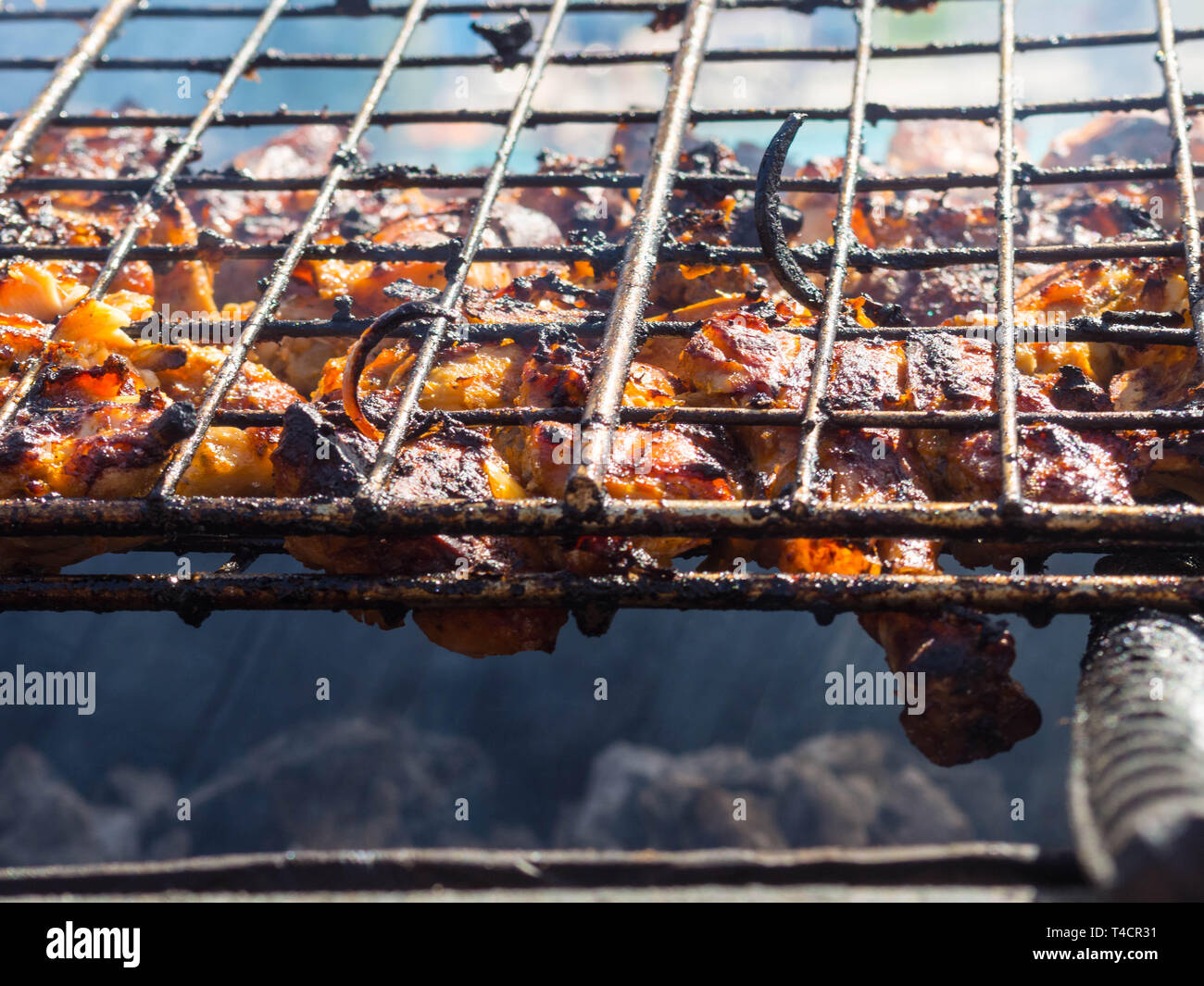 La viande grillée au charbon de barbecue cuisinière avec plein de fumée ...