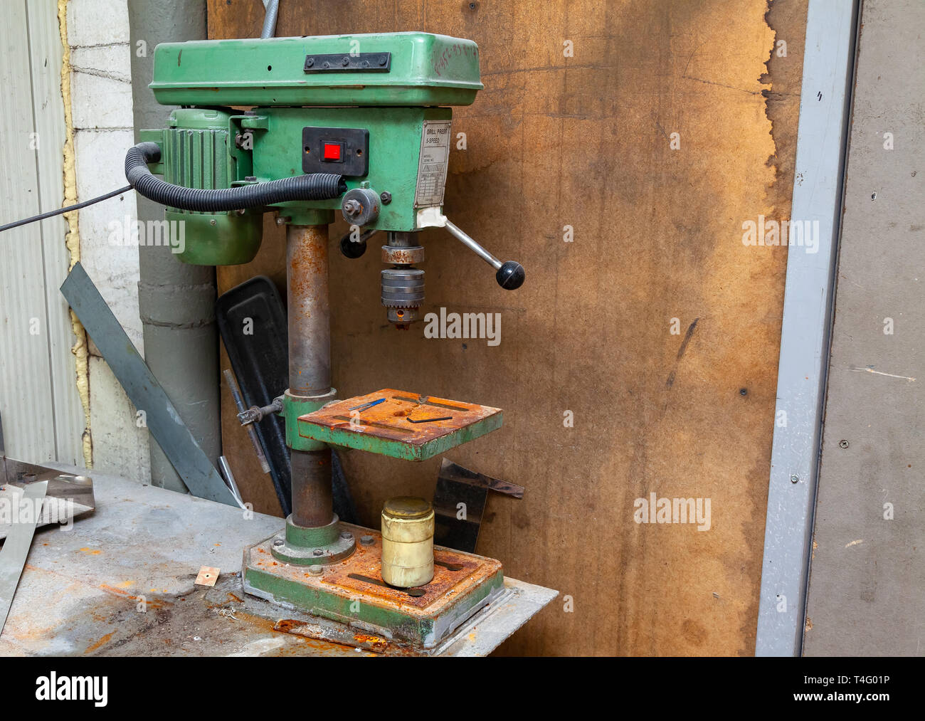 Vieille machine verte verticale avec un gros bouton rouge d ...