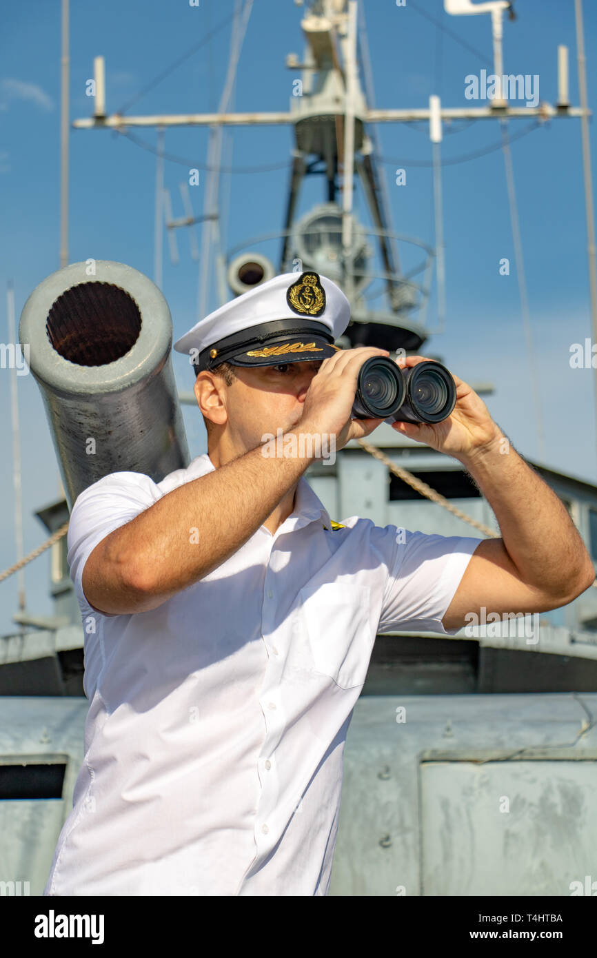 Le capitaine de navire debout à côté de canons et de regarder les ...