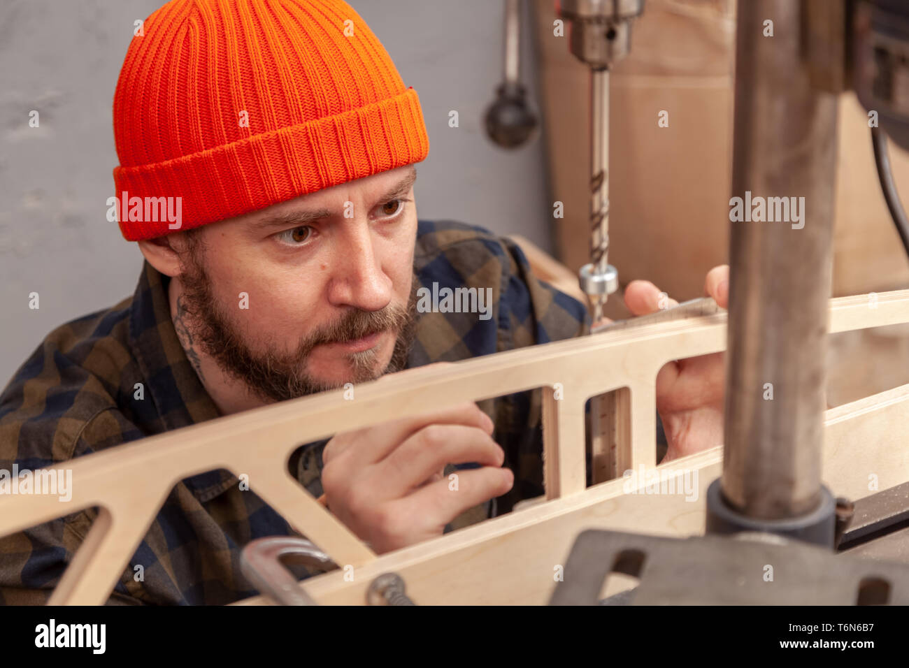 Carpenter l'homme dans les vêtements de travail perce un trou dans un ...