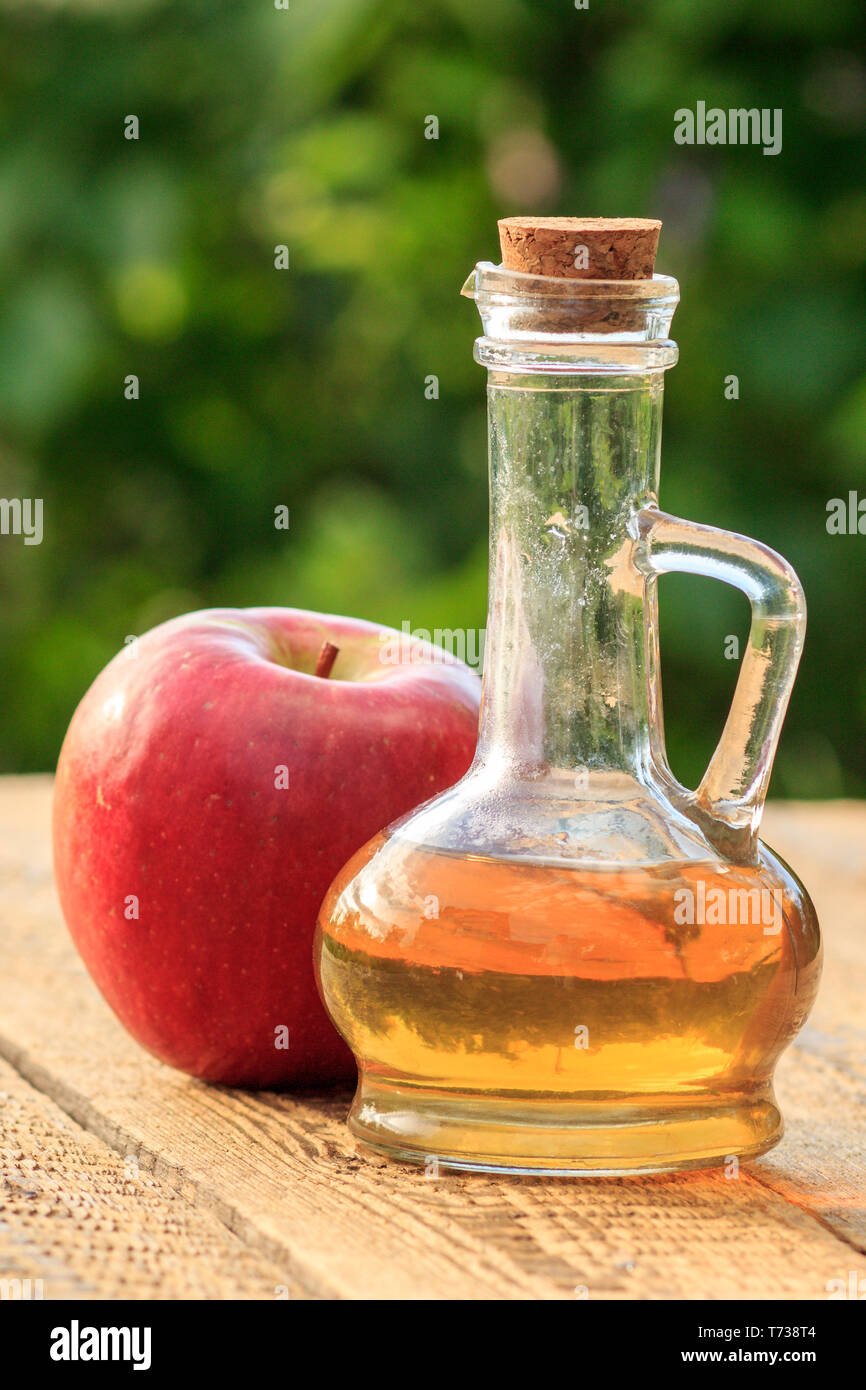 Vue rapprochée de vinaigre de pomme dans le flacon en verre avec ...