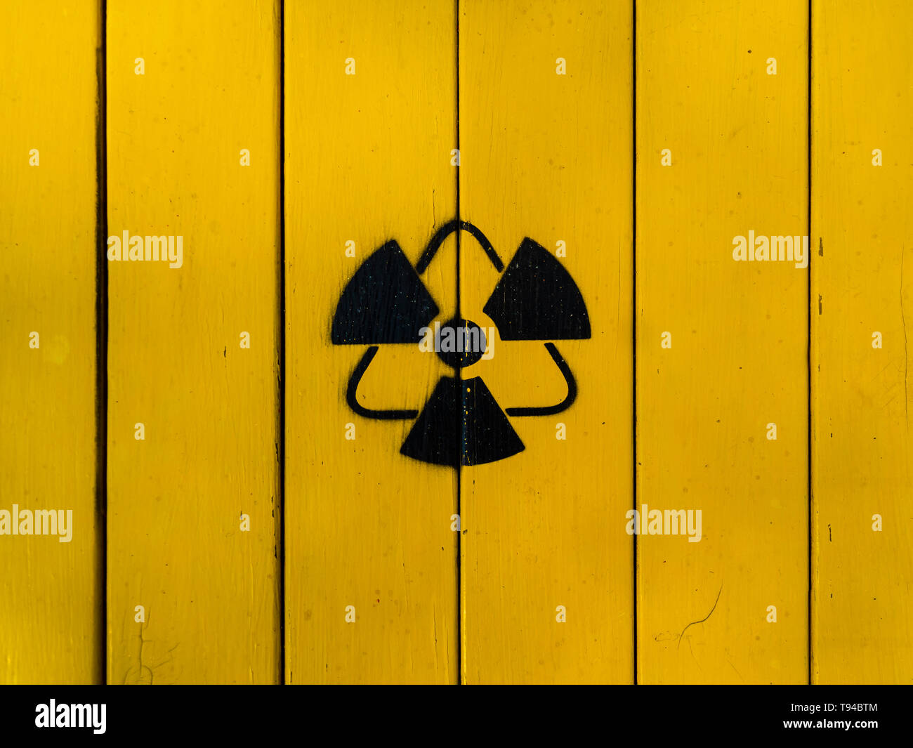 Signe de la radiation sur une planche de bois jaune. Signe radioactif ...