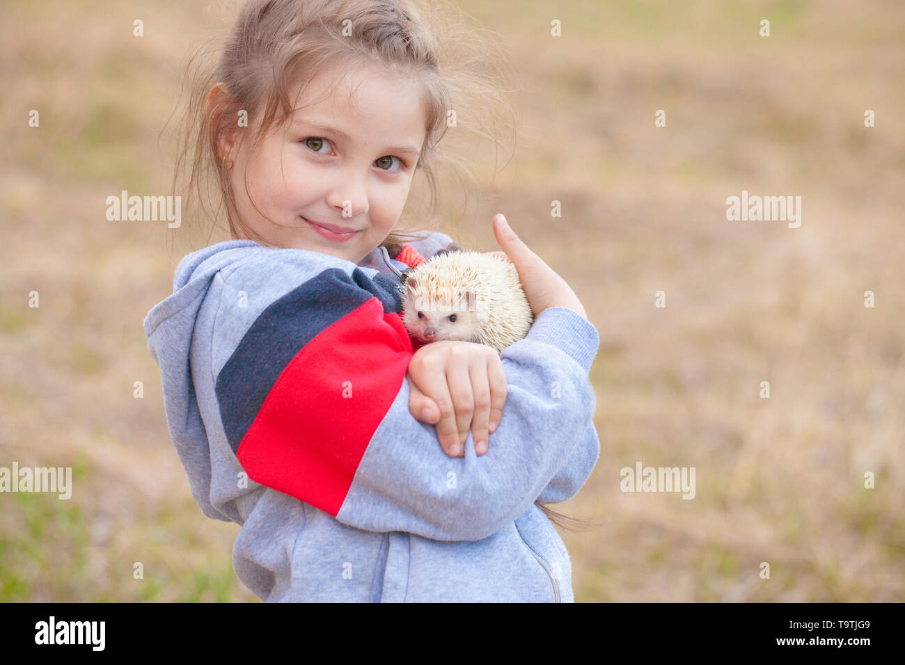 La notion de bonheur. Little girl hugging un hérisson. Un enfant joue ...