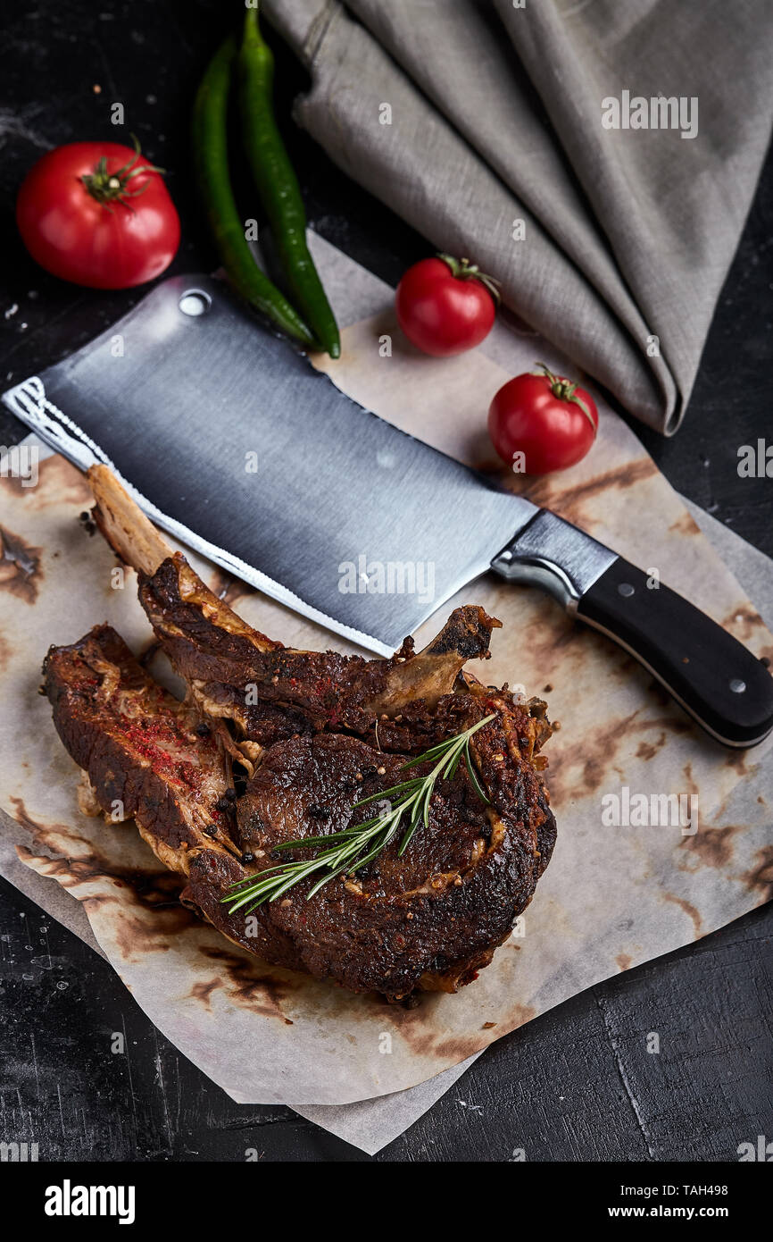 Tomahawk steak avec des légumes et un couteau sur la table. La viande ...