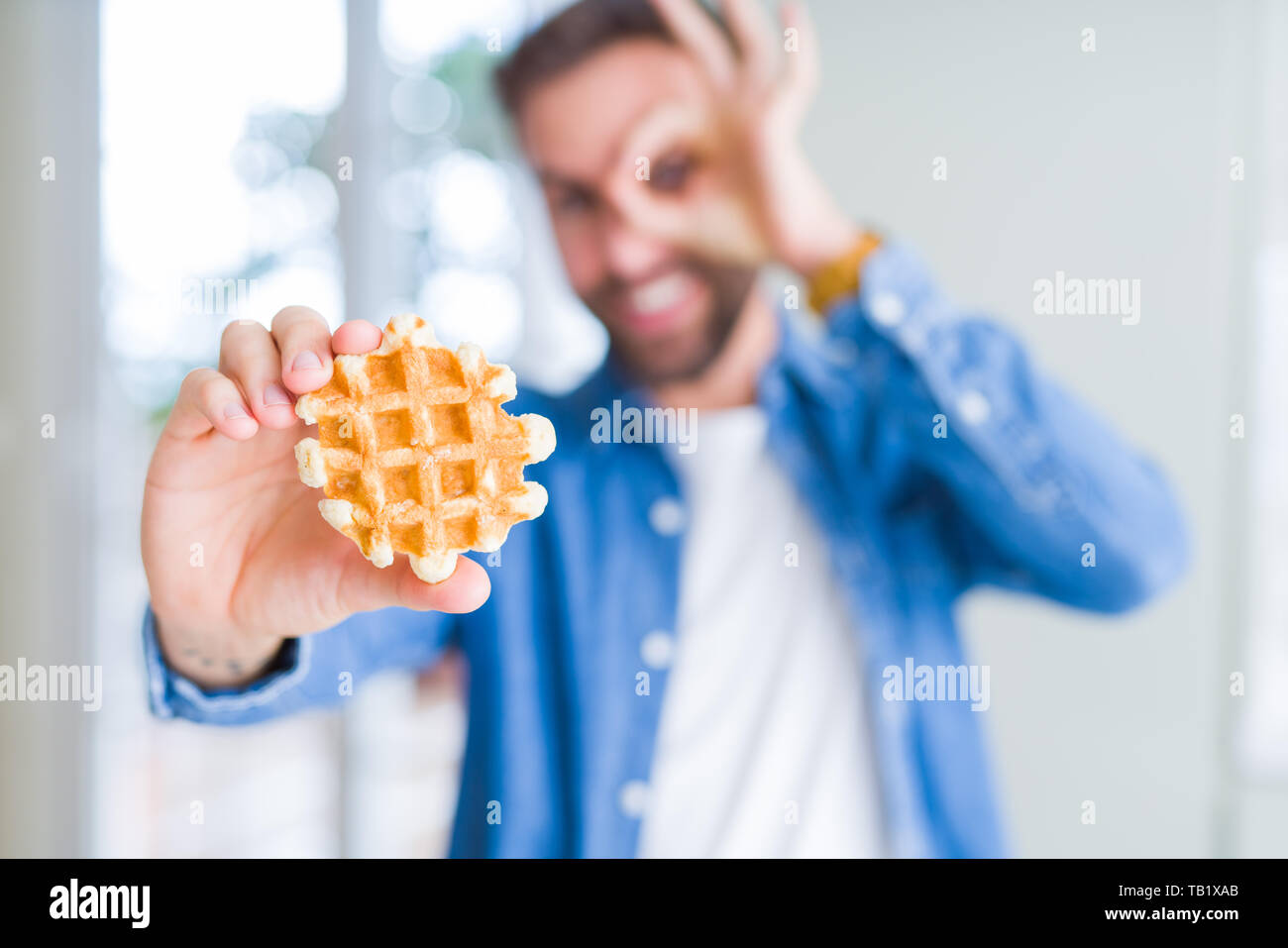 Bel homme doux de manger des crêpes belge avec happy smiling face faire ...