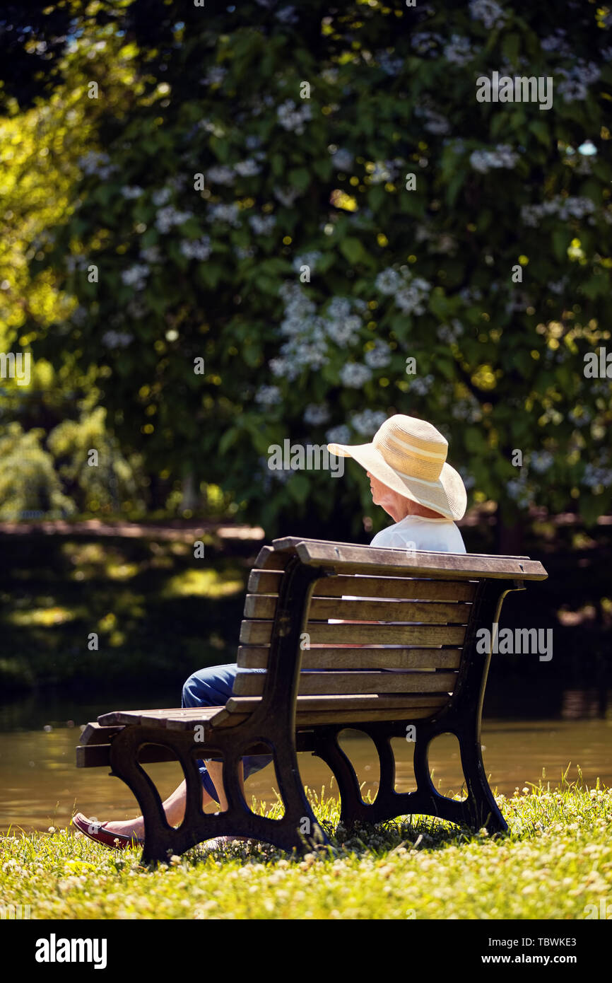 Vieille Dame Assise Sur Un Banc En Bois Banque De Photographies Et D