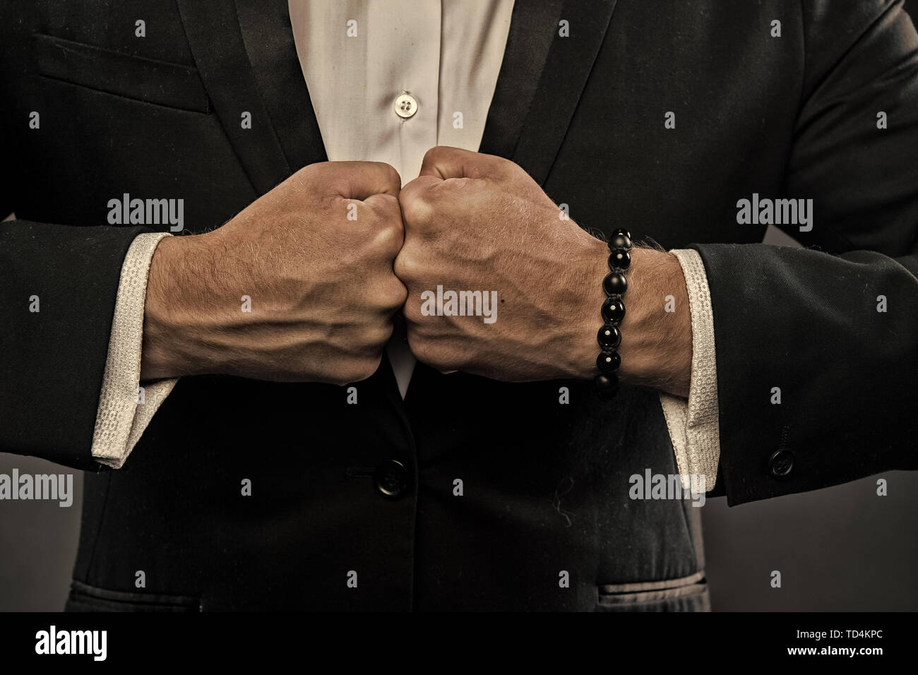 Les veines gonflées avec poings mâle et bracelet sur costume formel ...