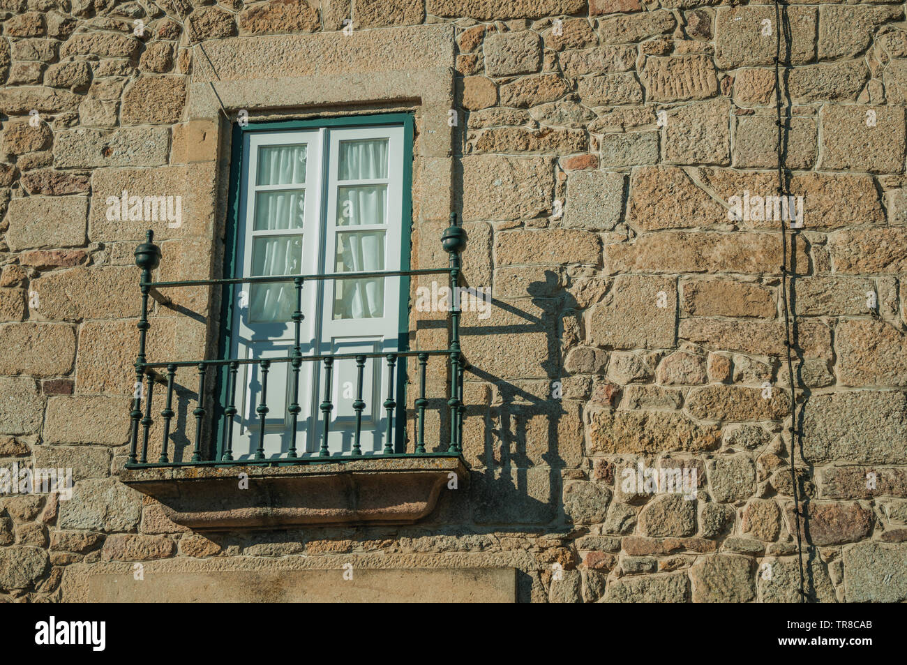 Balcon avec balustrade en fer forgé et porte vitrée sur un mur de ...
