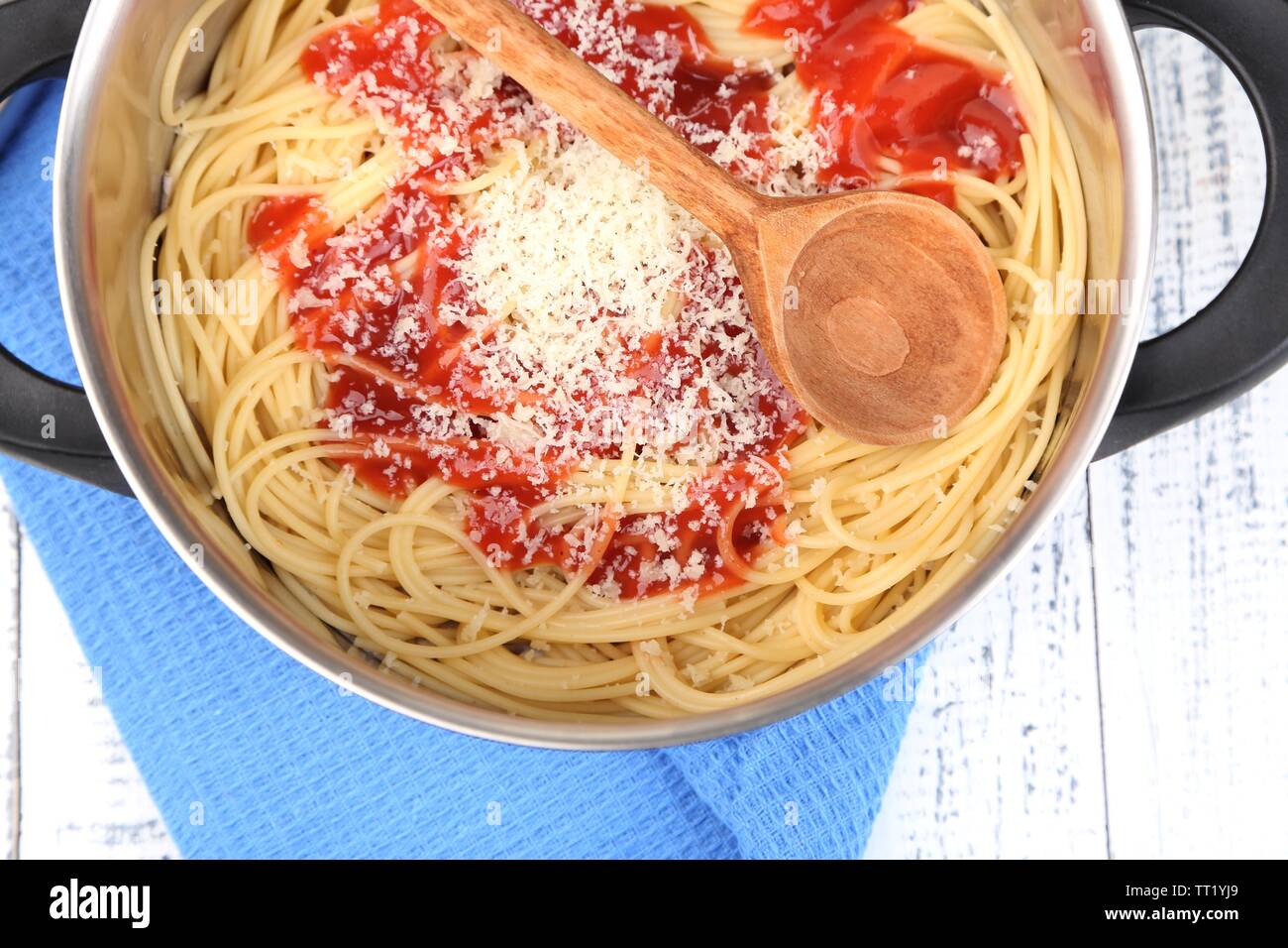 La composition avec de délicieux spaghetti dans pan, une râpe, du ...