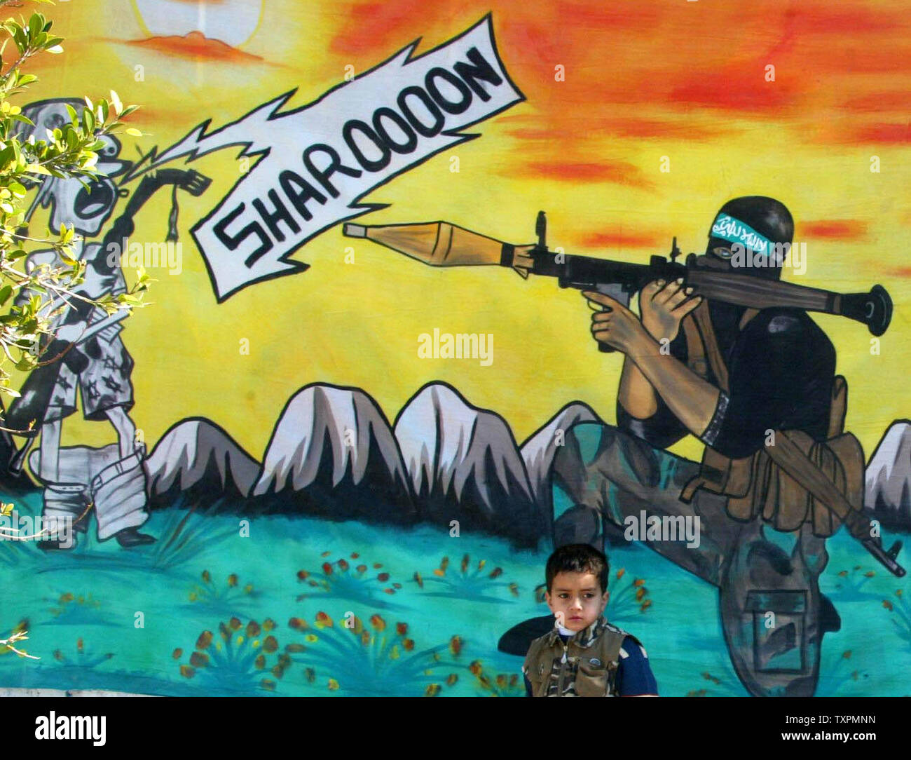 Un garçon palestinien se place en avant du Hamas et Sharon graffiti ...