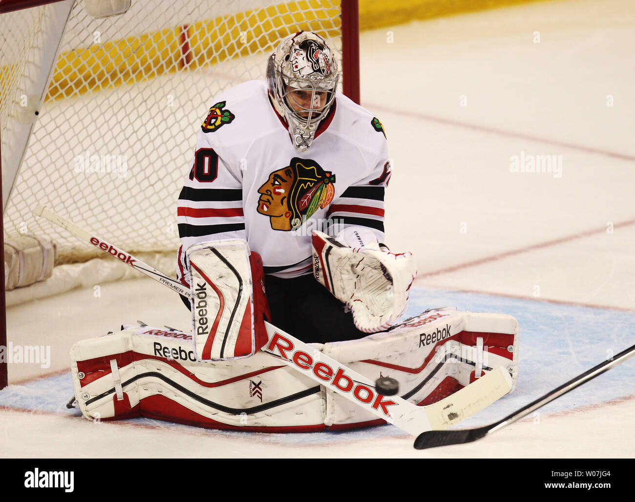 Le gardien des Blackhawks de Chicago Corey Crawford yeux la rondelle ...
