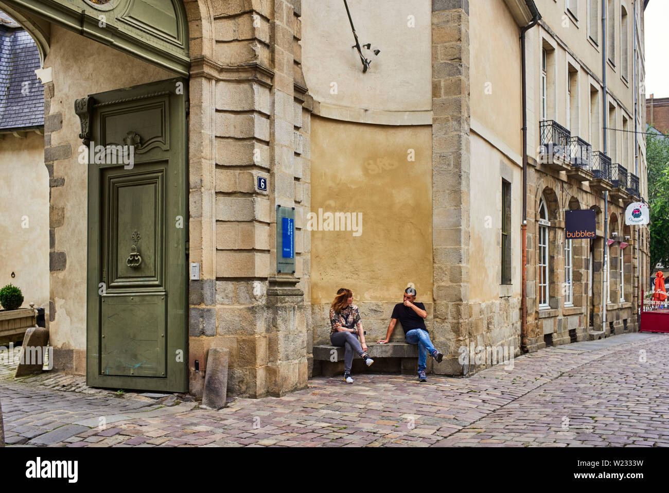 Un couple de personnes assises à l'extérieur de l'Hôtel de Ville de ...