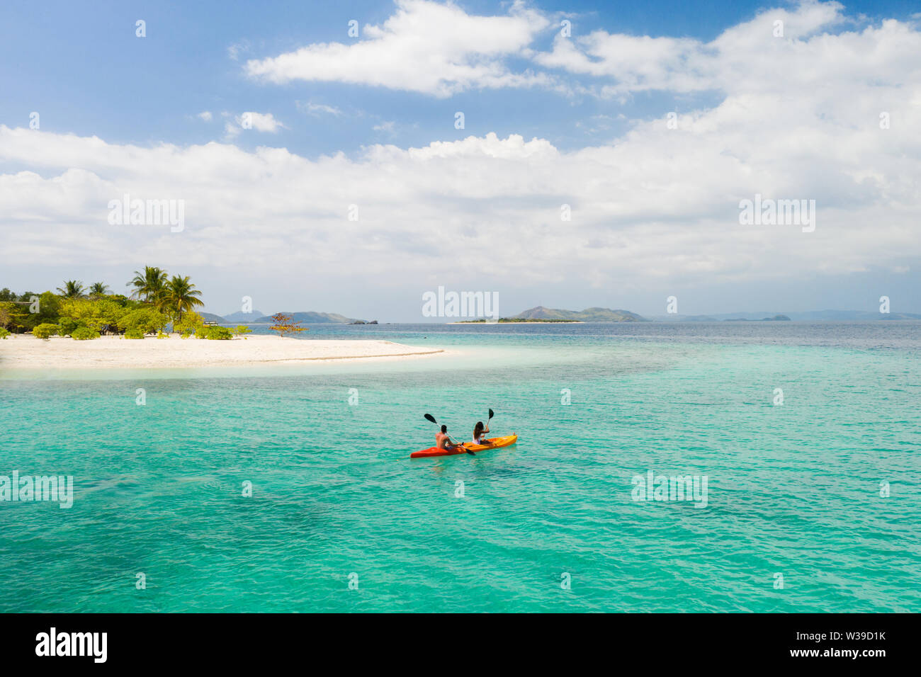 Kayak de couple sur une plage tropicale avec palmiers et l'eau bleue ...