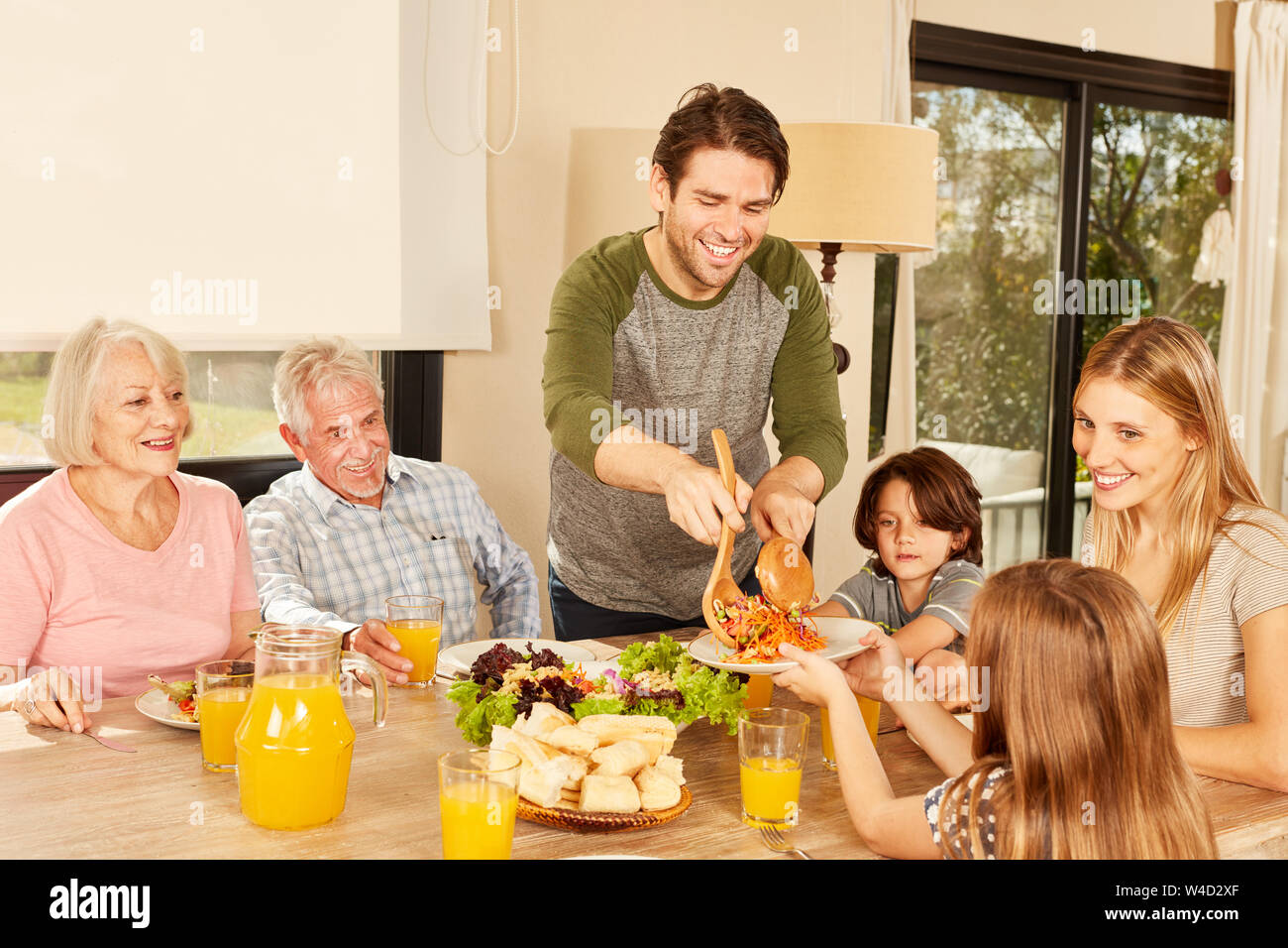 Famille avec enfants et grands-parents en train de dîner à la table d ...