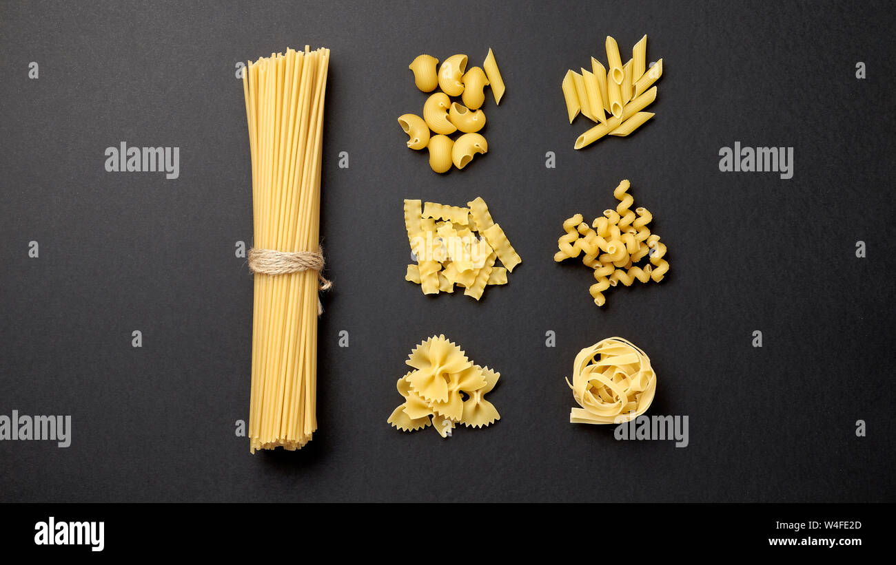 Différents types de pâtes sur fond noir. Vue d'en haut. Diverses formes ...