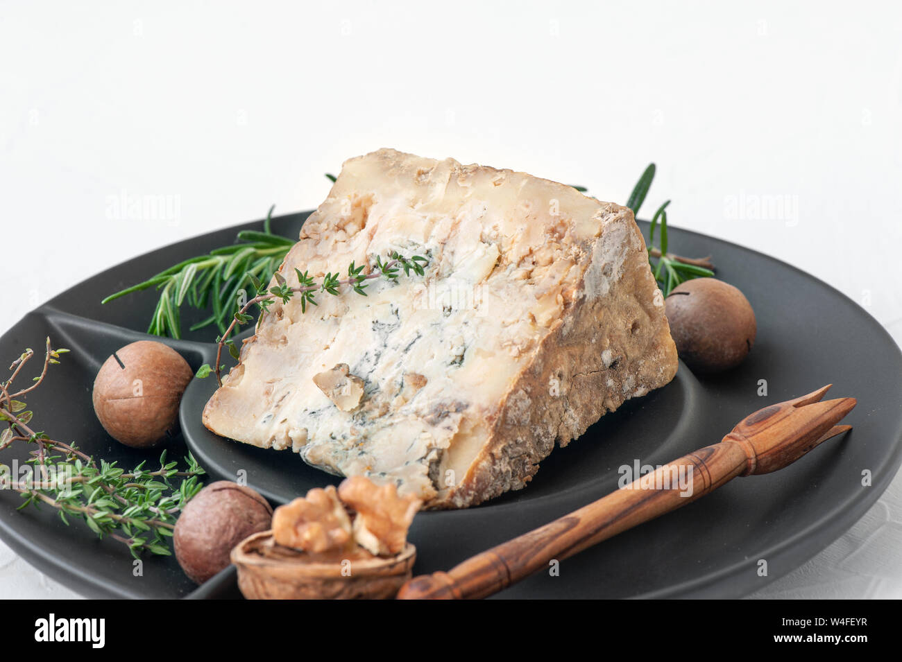 Une tranche de fromage Stilton vieilli bleu sur une table en bois. Le ...