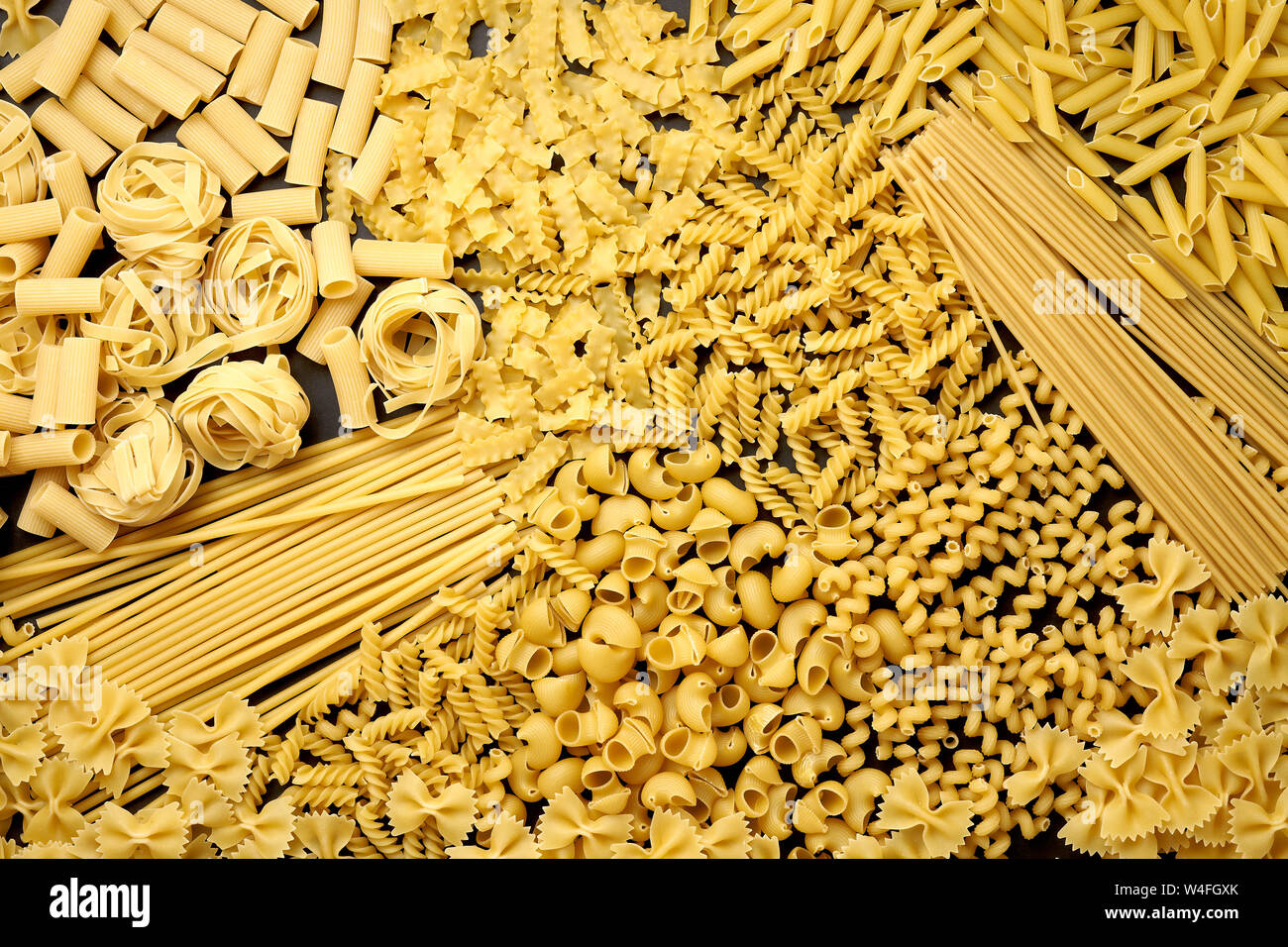 Différents types de pâtes sur fond noir. Vue d'en haut. Diverses formes ...