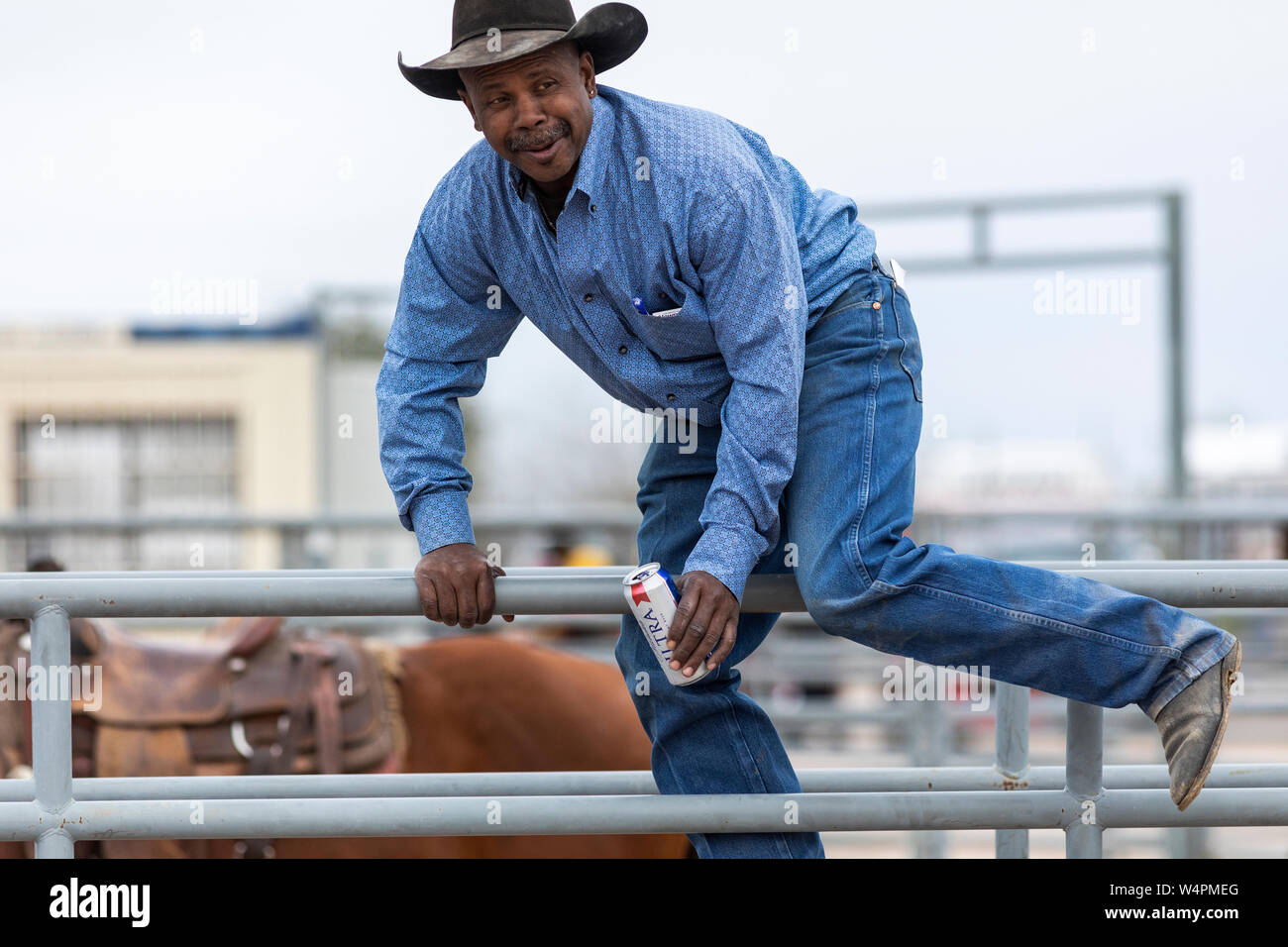 Un cowboy houblon sur une clôture tenant une canette de bière à l'az ...