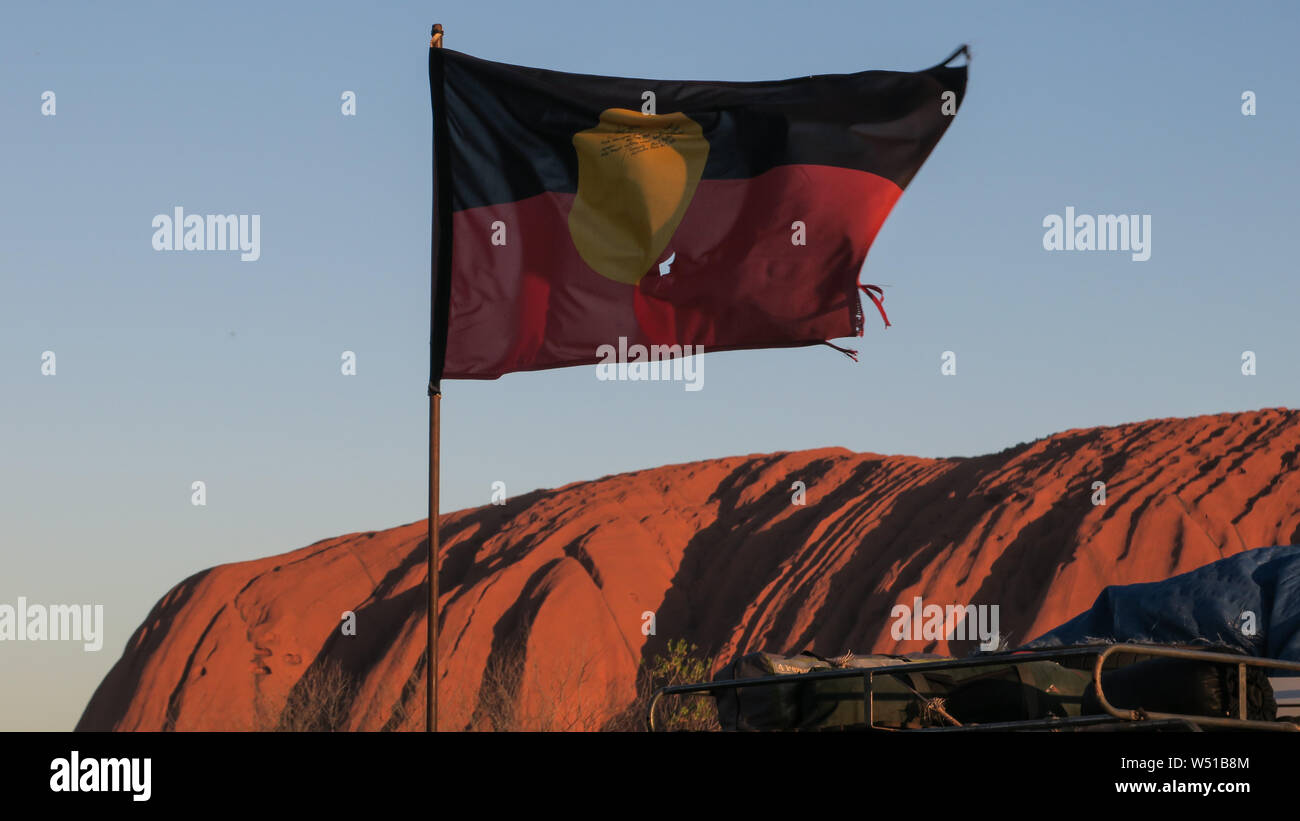Le drapeau flotte autochtones devant ofUluru ou Ayers Rock en Australie ...