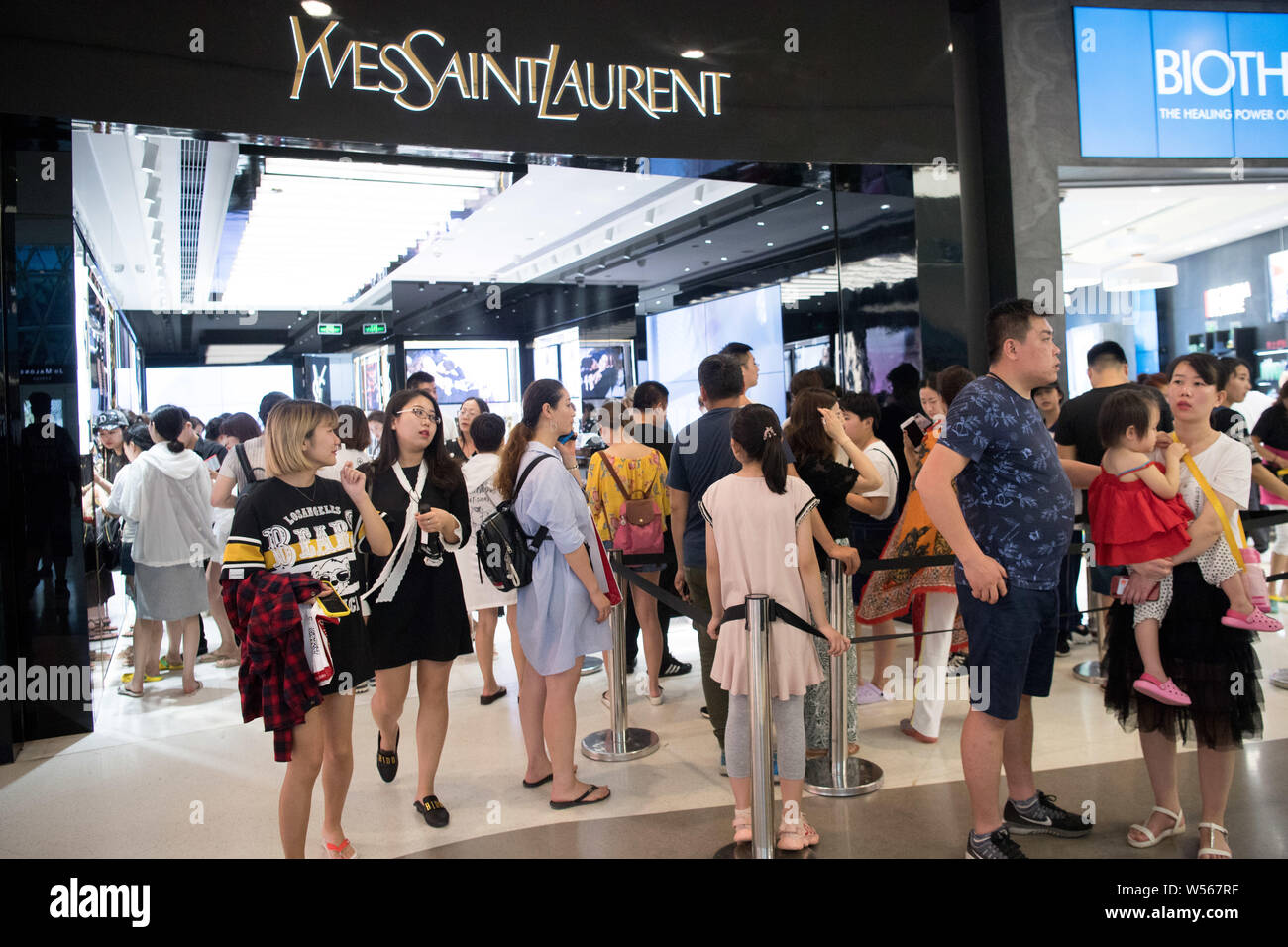 Les clients en file d'attente devant un magasin d'Yves Saint Laurent (YSL) à la franchise ...