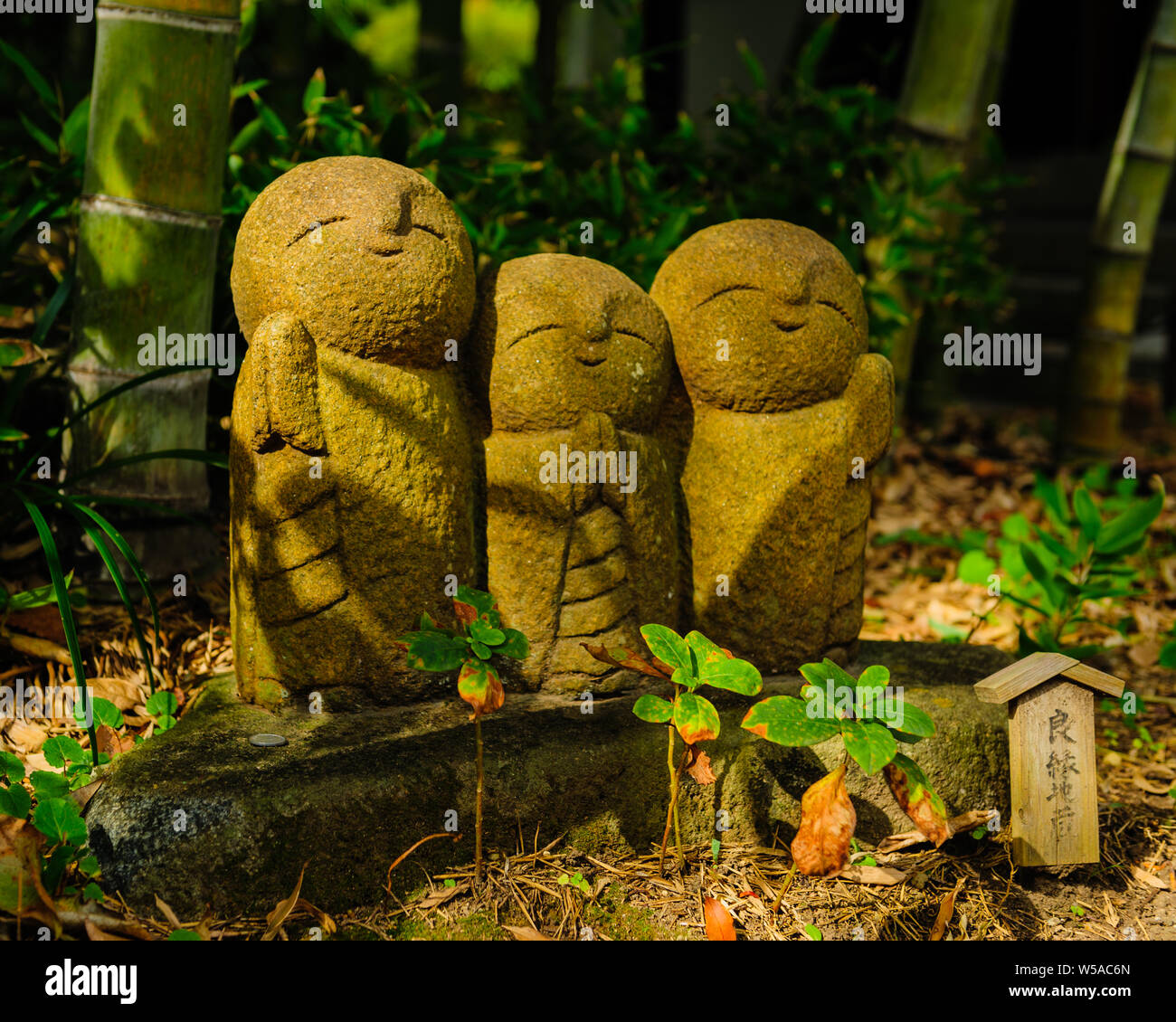 Petite statue en pierre d'un petit moine priant dans une drôle à la ...