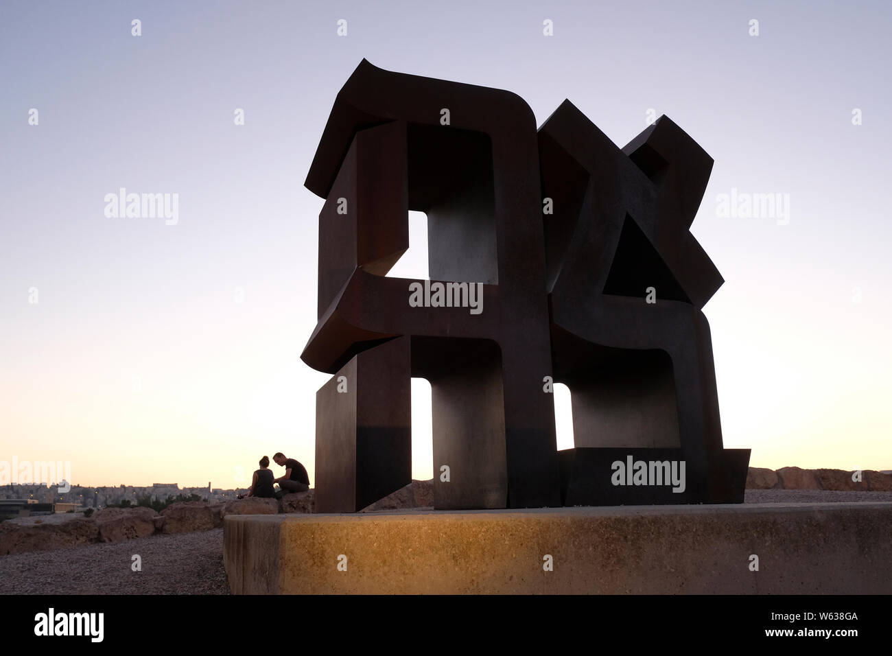 Un couple assis à côté de la sculpture Ahava ( amour ) de Robert ...