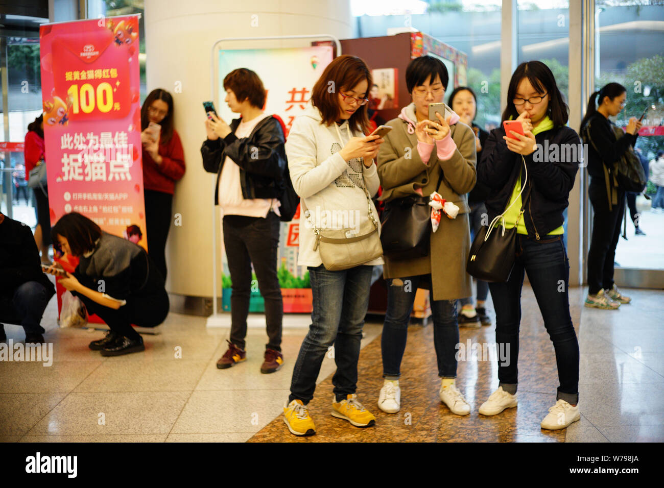 Les résidents locaux utilisent leurs smartphones pour attraper les chats 'Tmall' pour obtenir ...