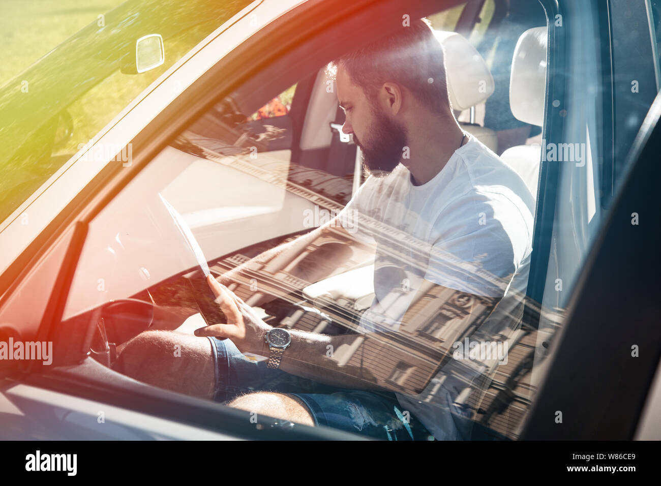 L'homme derrière la roue commence une voiture blanche, les vêtements ...