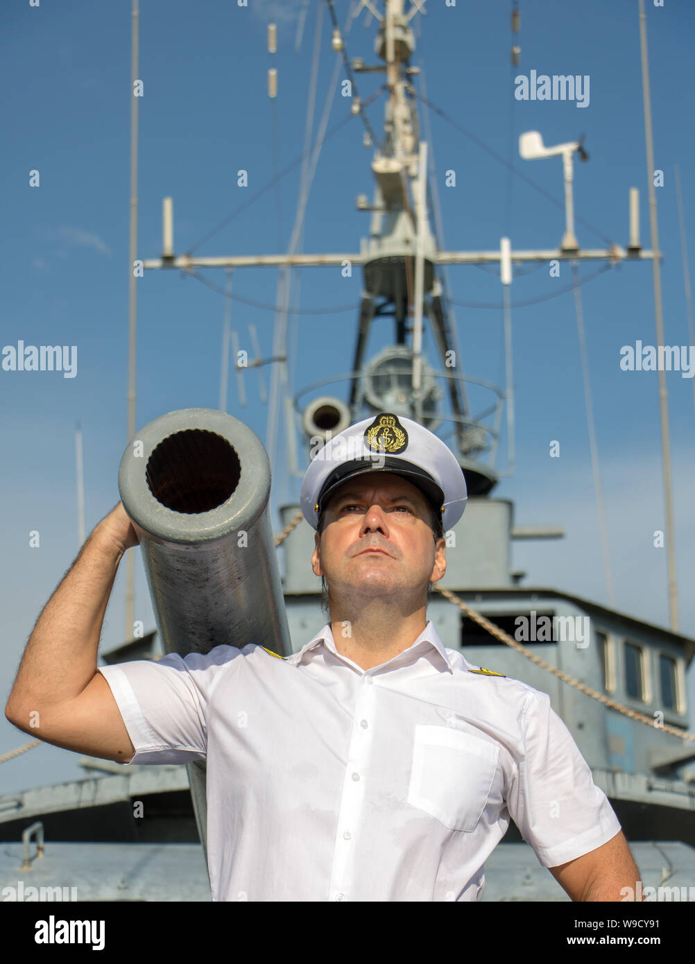 Un officier de marine sous une ship's cannon.Le capitaine en uniforme ...
