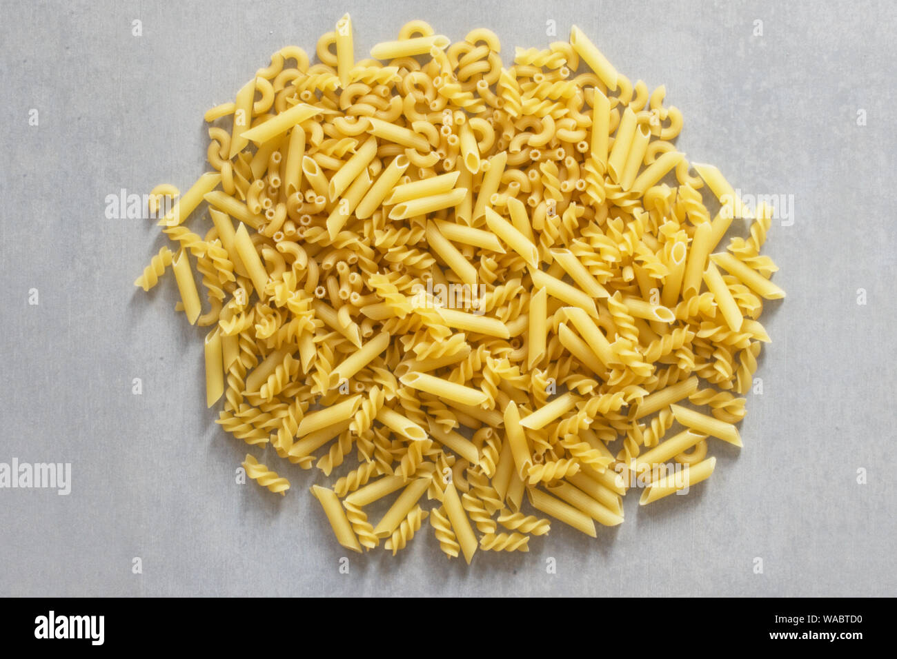 Des tas de différents types de pâtes haut Vue sur fond gris. Beaucoup ...